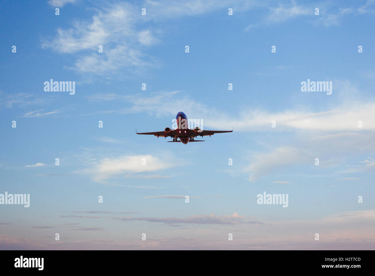 Airplane landing with pretty sky in background Stock Photo - Alamy