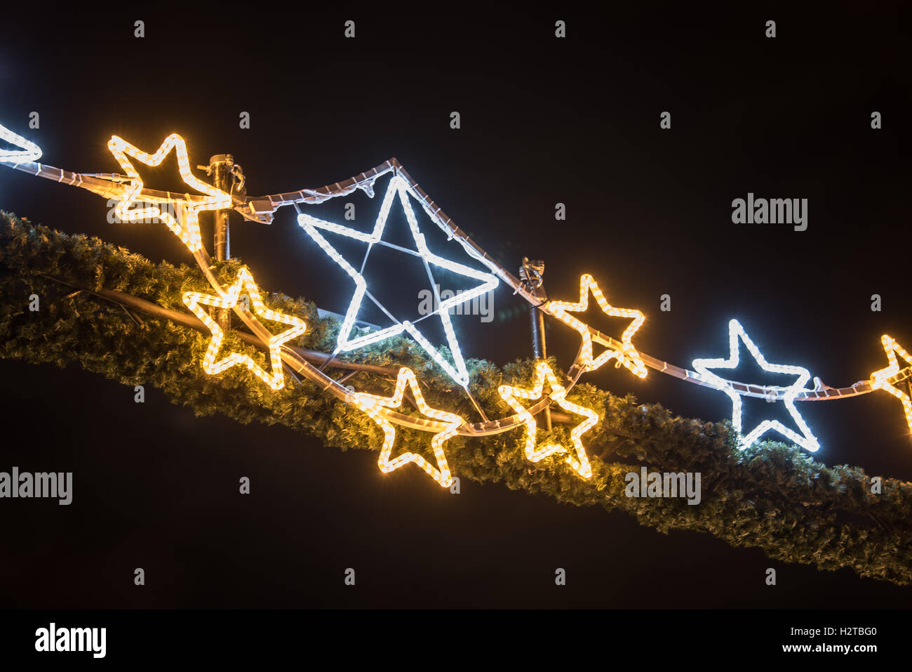 chain of bright christmas stars on dark background Stock Photo - Alamy