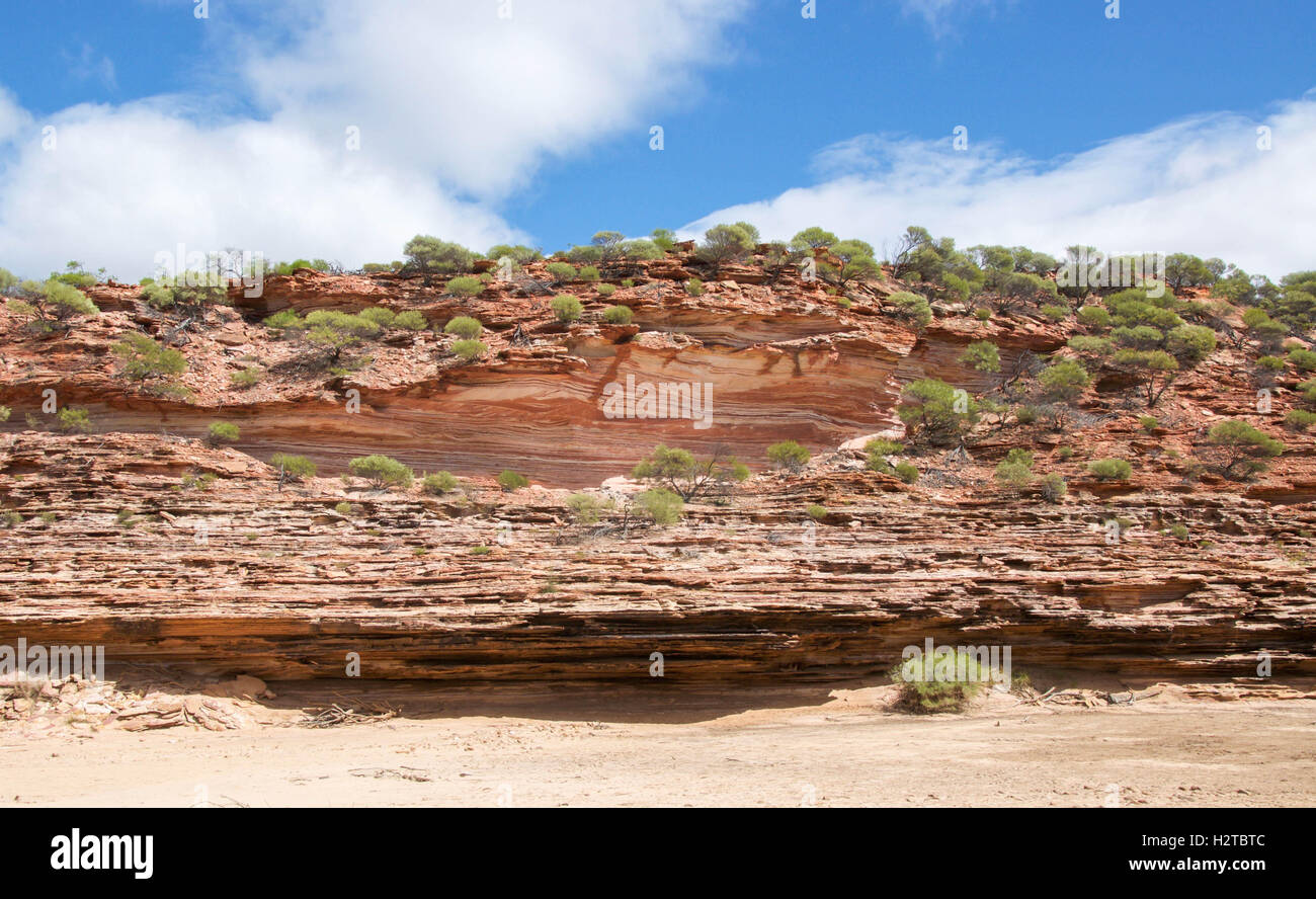 Unique banded sandstone bluffs surrounding the dry Murchison River ...