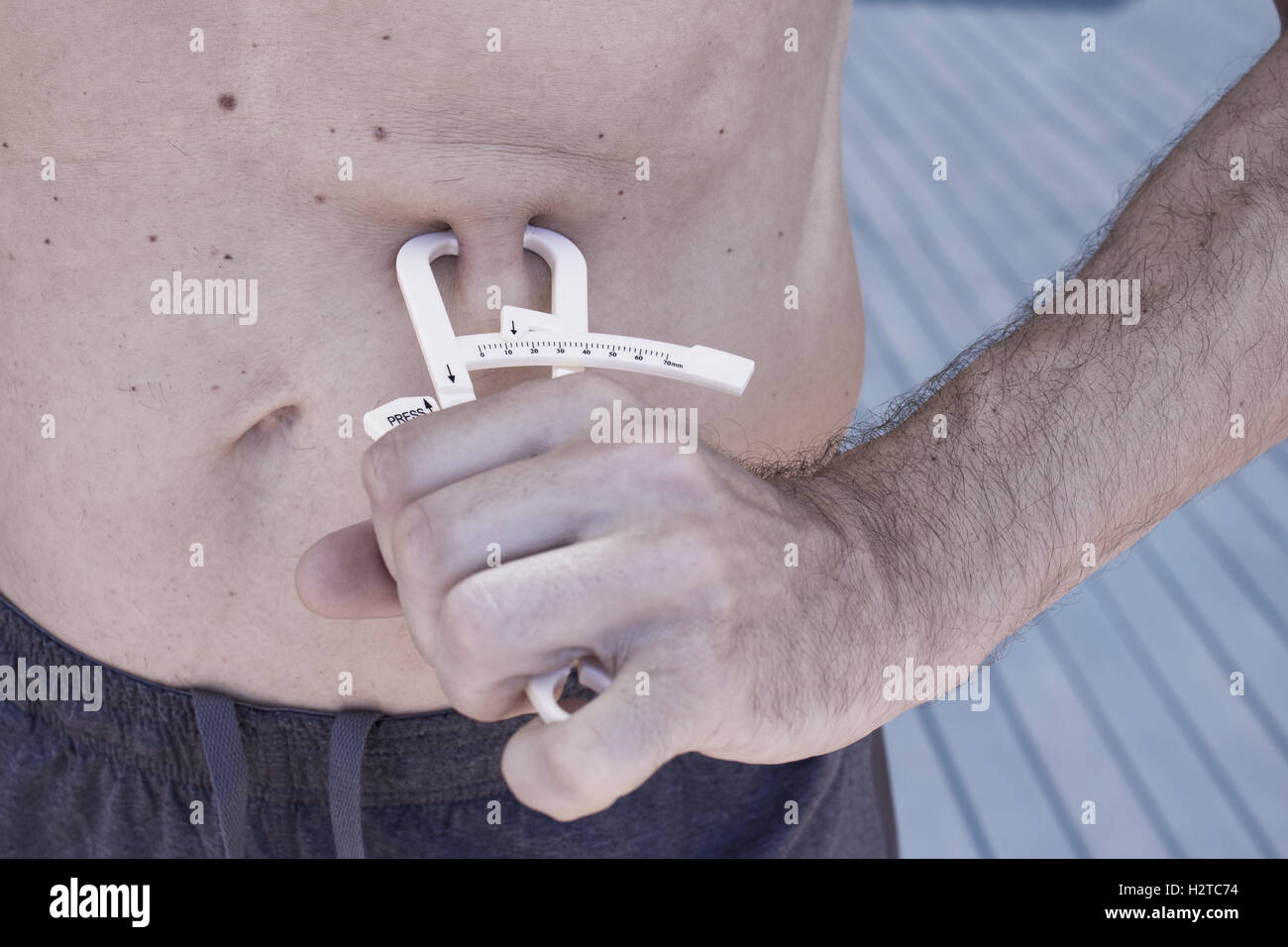 Body of a man measuring contour and body fat Stock Photo - Alamy