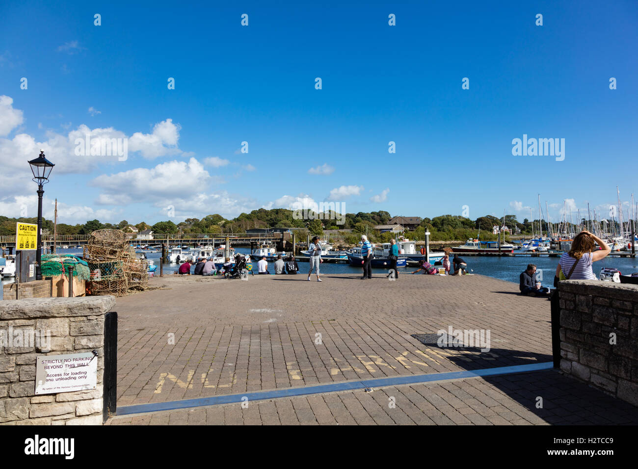 Families crabbing and watching on Lymington Quay, Hampshire, UK Stock ...