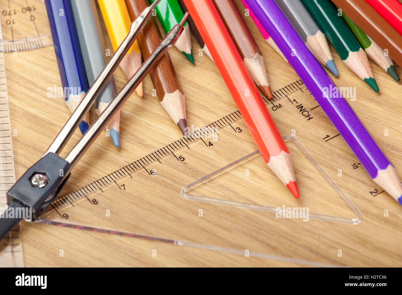 Coloring pencils spilled on a wooden desk with a protractor set Stock ...