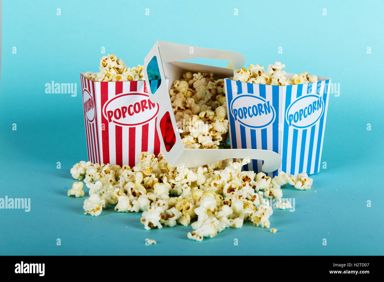 Bucket of popcorn against a blue background Stock Photo - Alamy