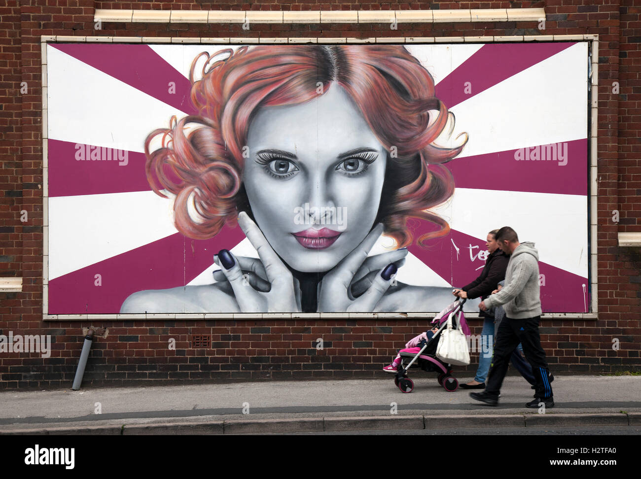 Pedestrian walking past street art, graffiti wall painting, decoration ...