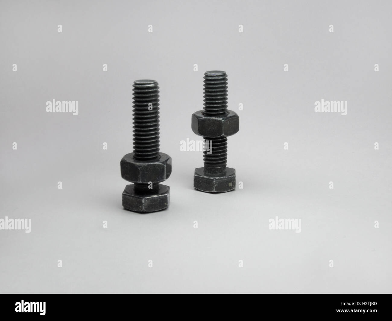 Two connecting bolts in black color, with nuts, screwed on them Stock ...