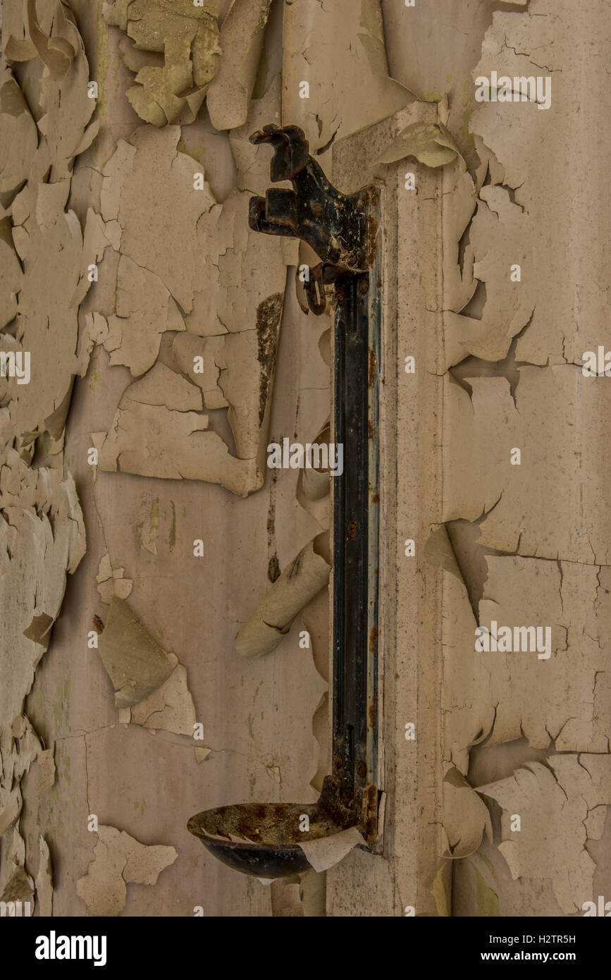 Peeling paint surrounds an old candle holder inside Maiden Law Hospital ...