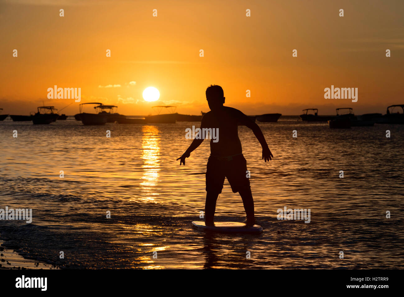 Surfing at sunset at Tamarin beach, Mauritius Stock Photo - Alamy