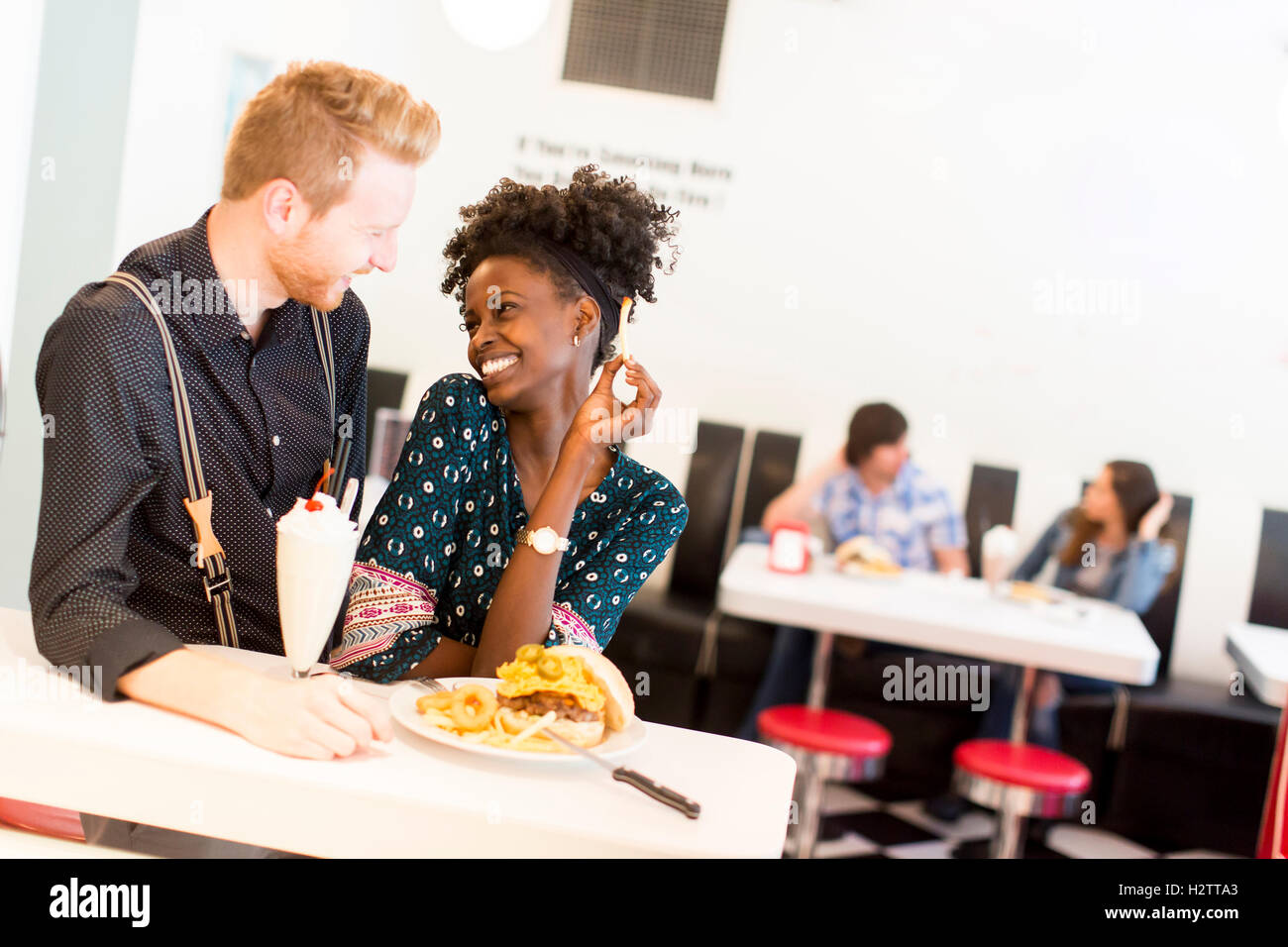 View of the young couple eating in the diner Stock Photo - Alamy