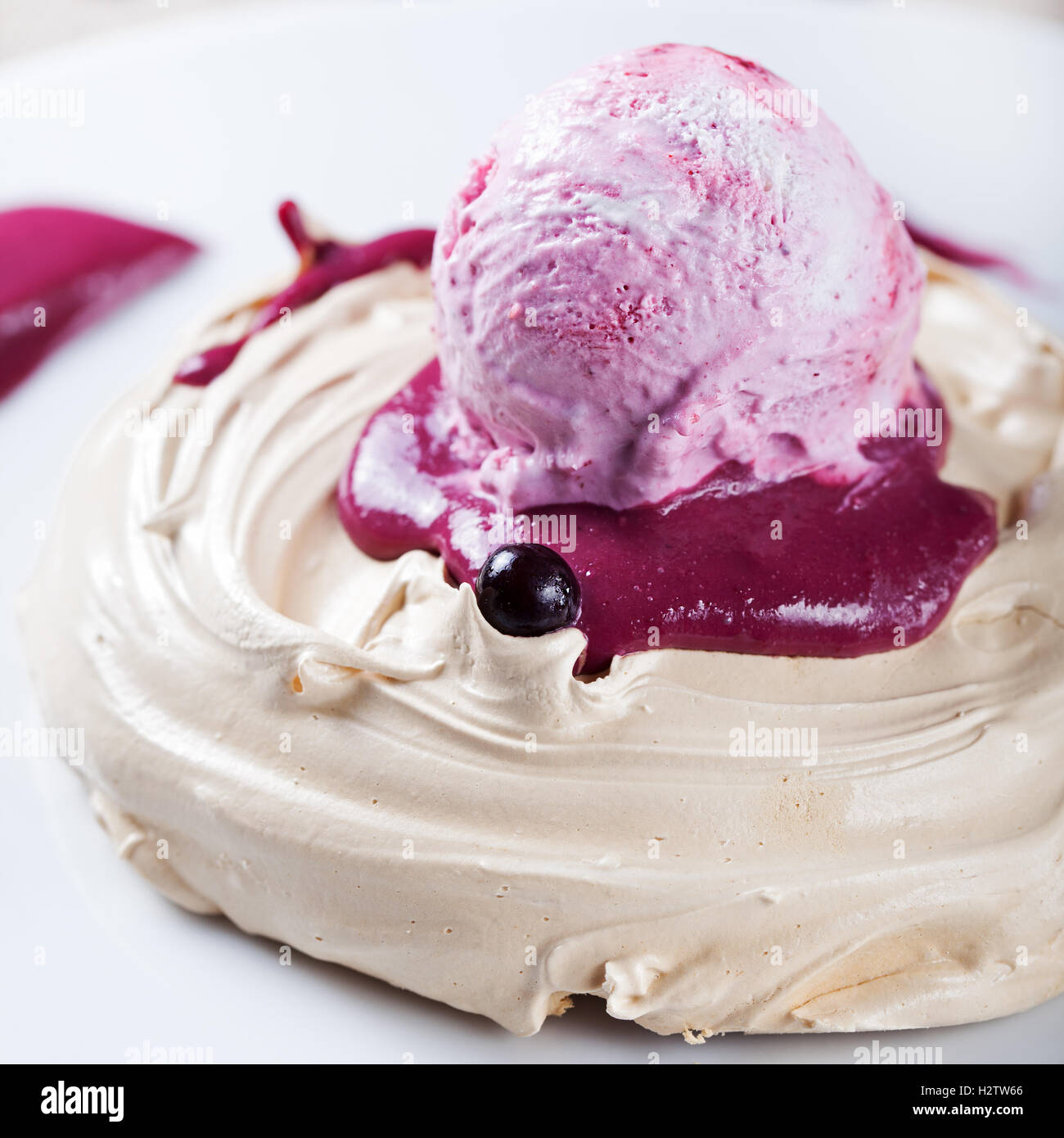 Meringue with berry ice cream on a white plate Stock Photo - Alamy