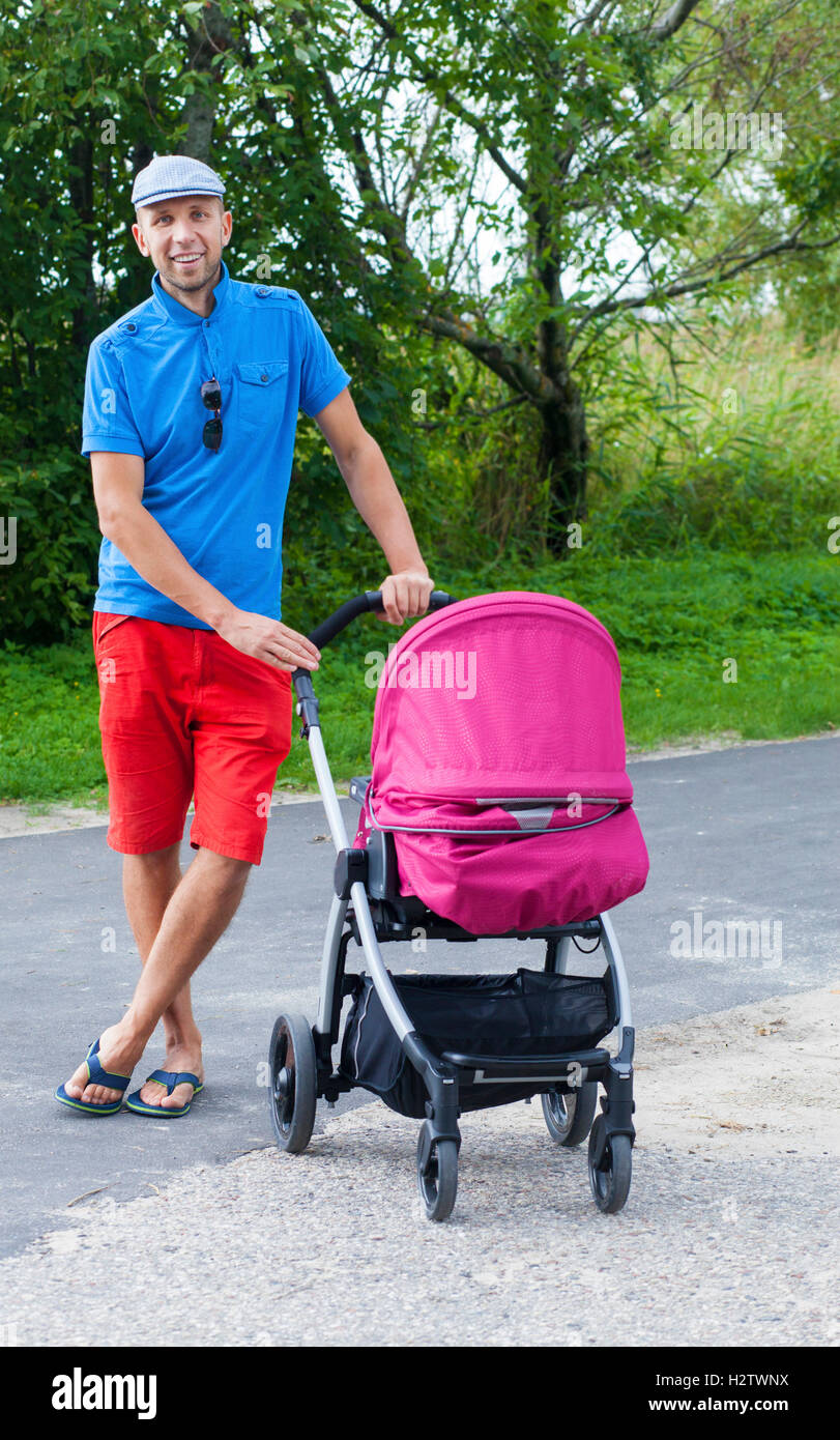 Happy young father with a stroller outdoors Stock Photo - Alamy