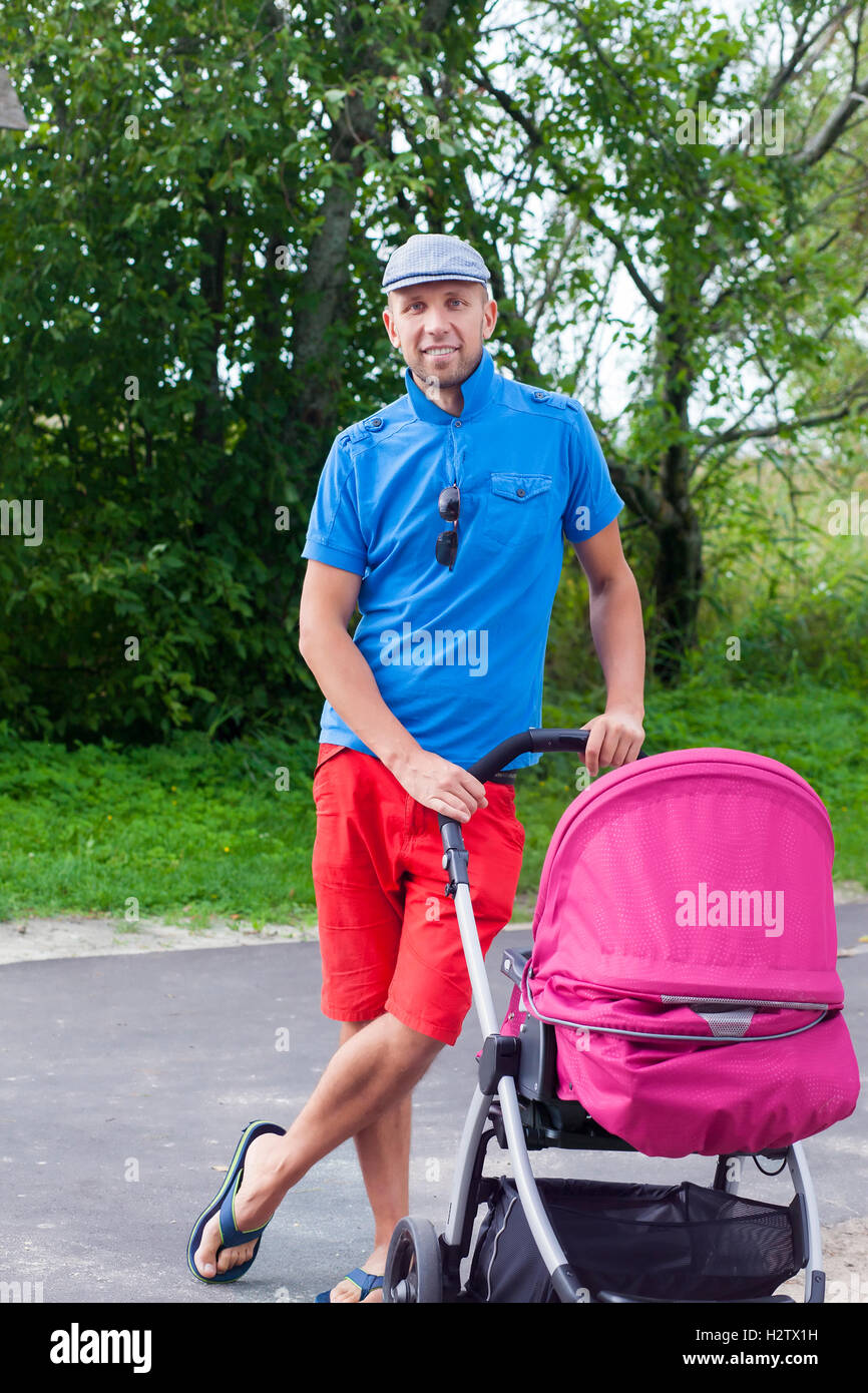 Handsome young man holding a baby stroller Stock Photo - Alamy