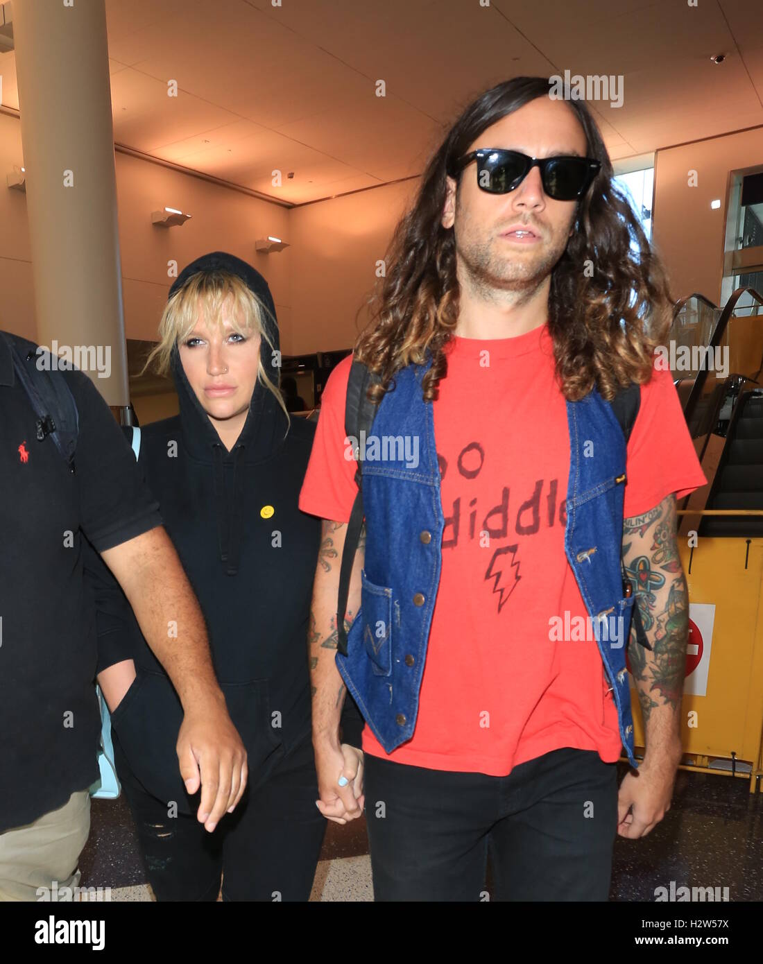 Kesha arrives at Los Angeles International Airport with boyfriend Brad ...
