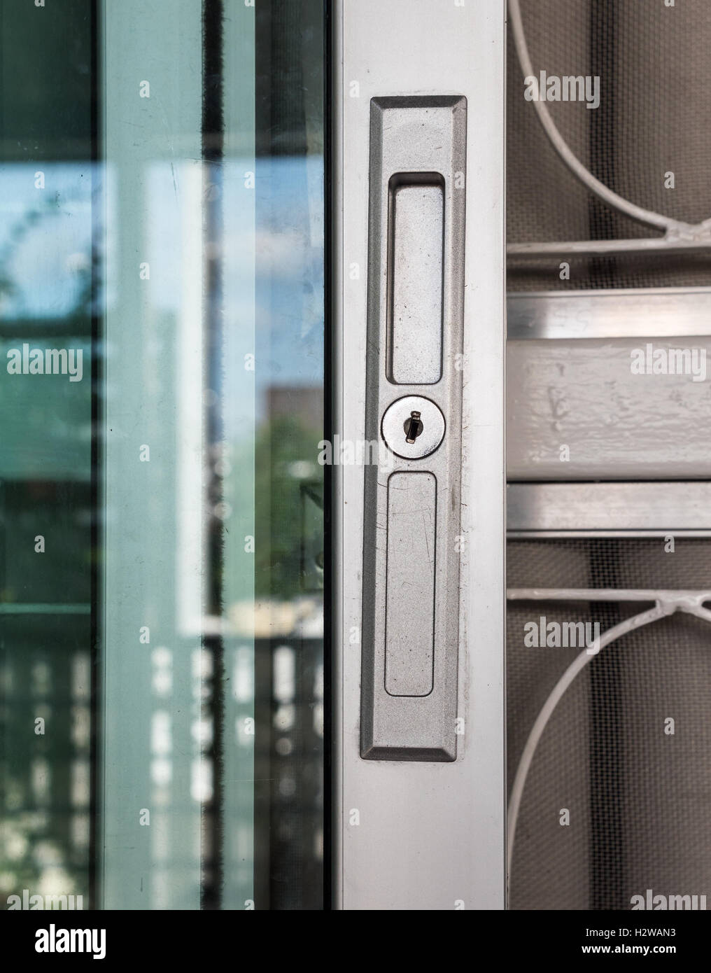 Keyhole on the metal frame of the glass door Stock Photo - Alamy