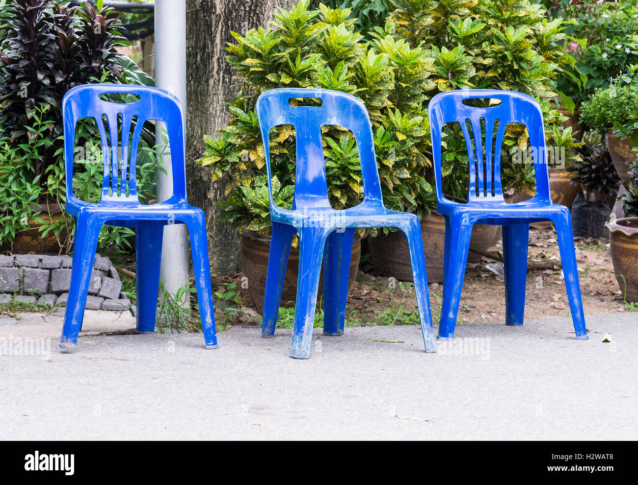Blue plastic chair near the road edge in the city park Stock Photo - Alamy