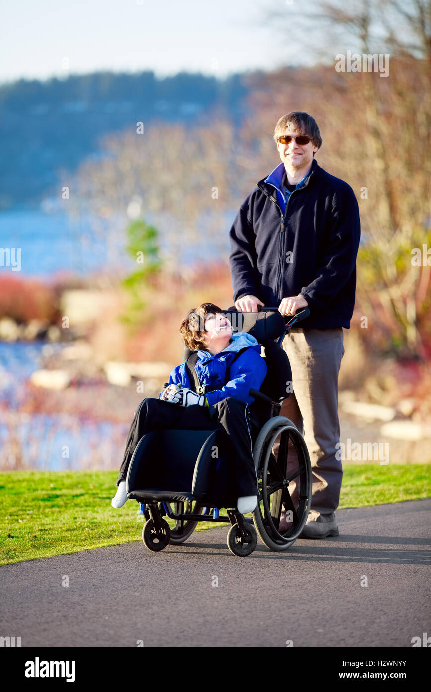 Father walking with disabled son in wheelchair Stock Photo - Alamy