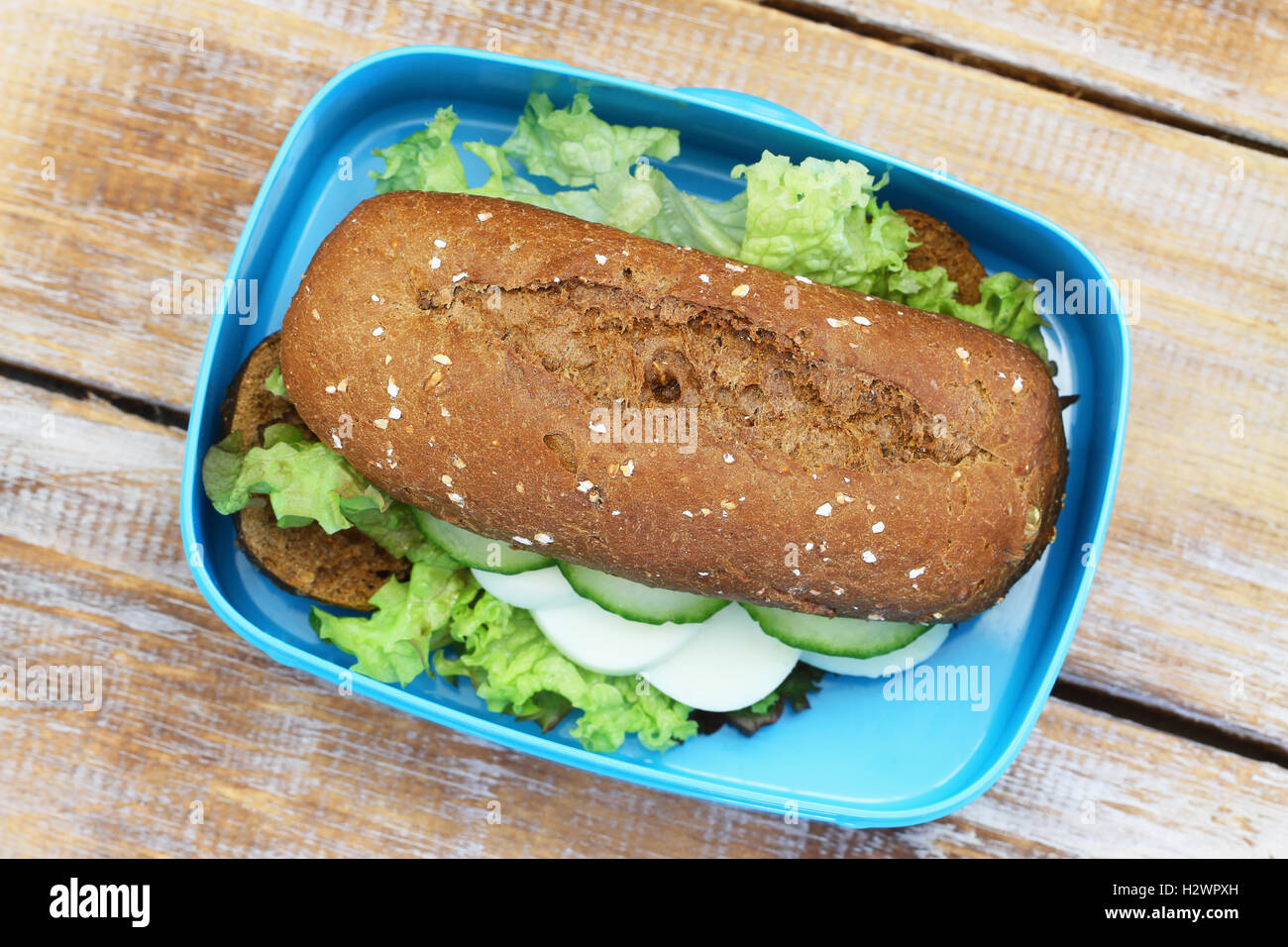 Healthy lunch box containing whole grain bread roll with hard boiled ...