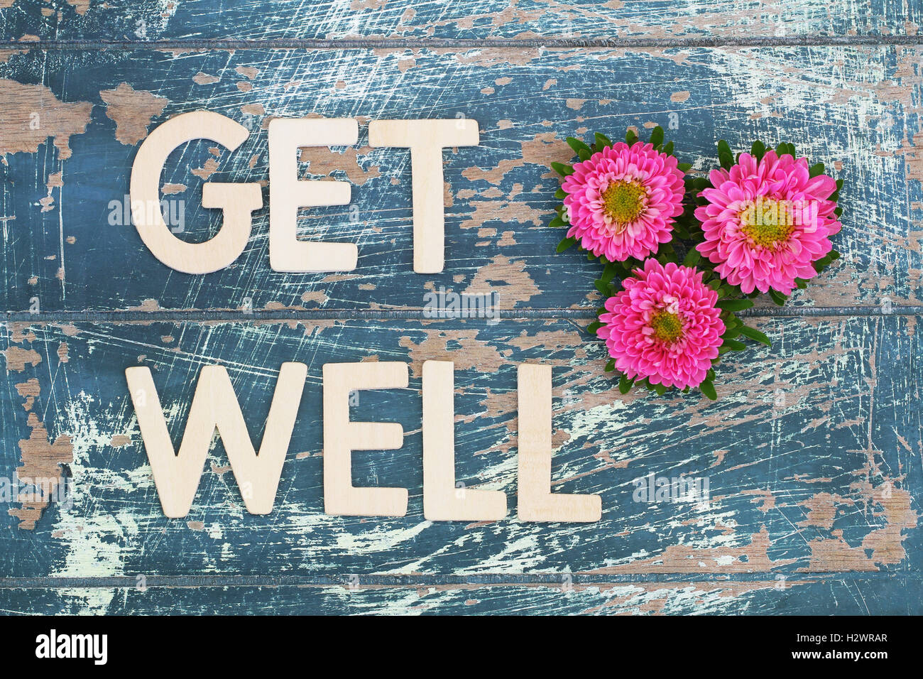 Get well written on rustic wooden surface and pink daisies Stock Photo ...
