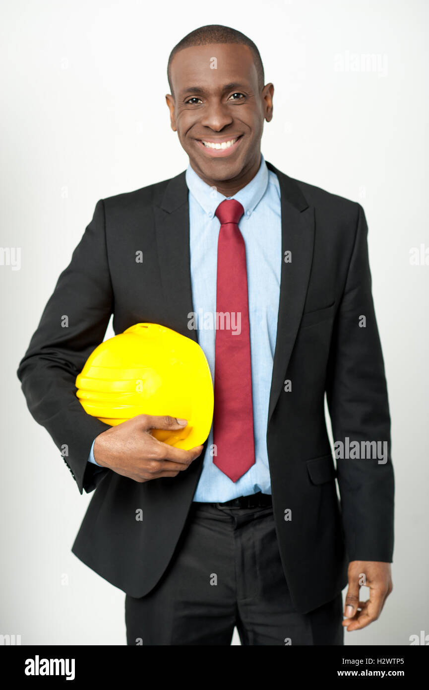 Smiling engineer holding a hard hat Stock Photo - Alamy
