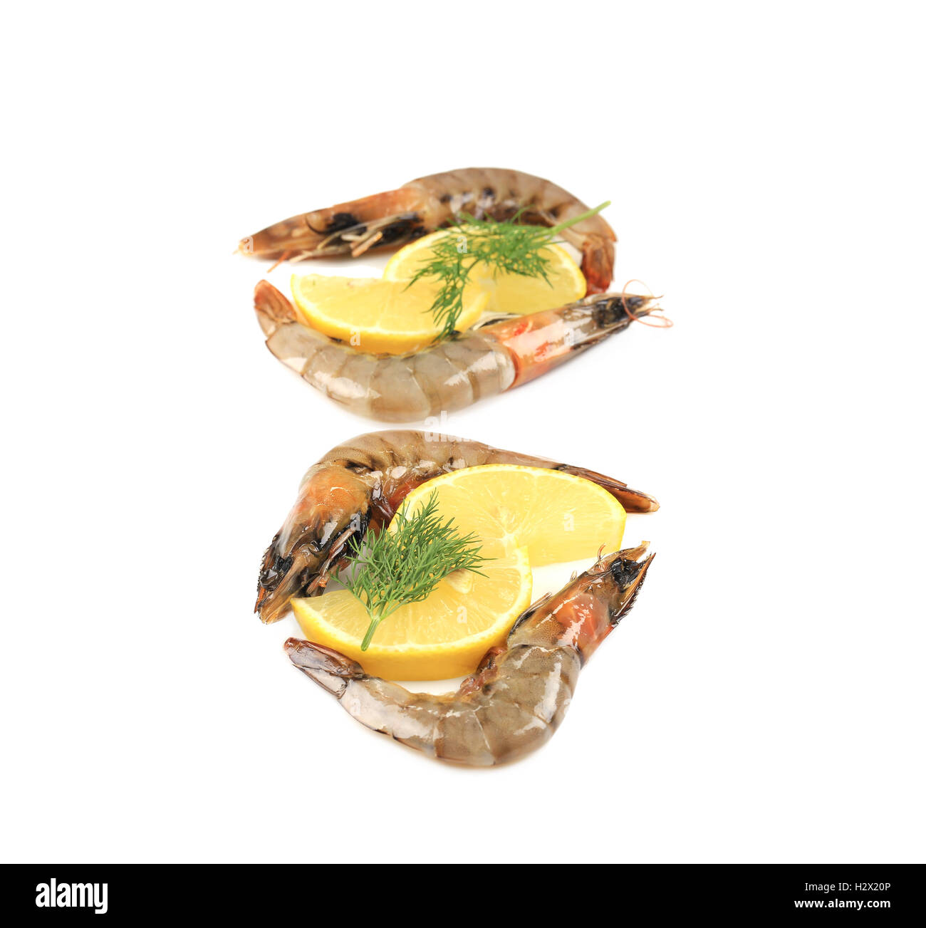 Four small raw shrimp with lemon and dill Stock Photo - Alamy