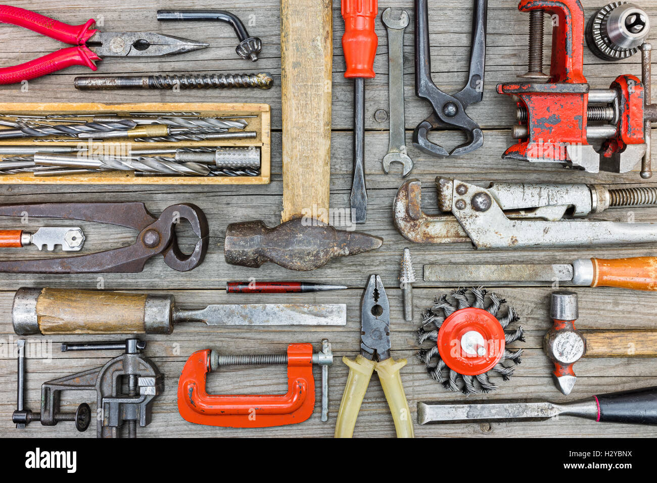 different old rusty hand tools and accessories on gray wooden boards ...