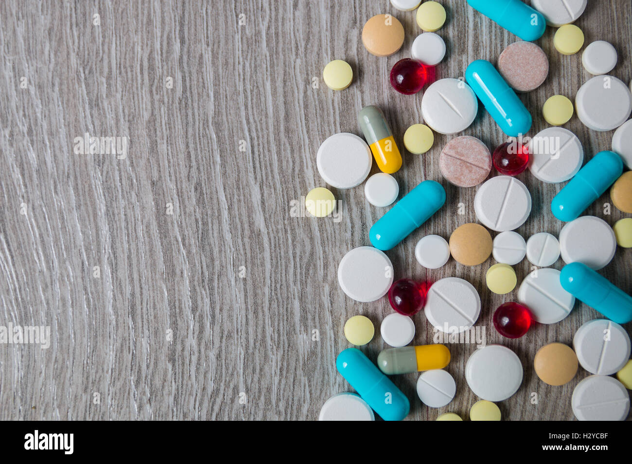 A lot of colorful medication and pills from above on grey wooden ...