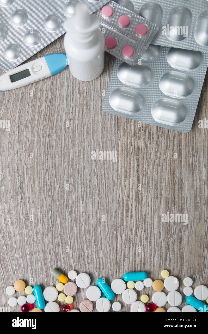A lot of colorful medication and pills from above on grey wooden ...