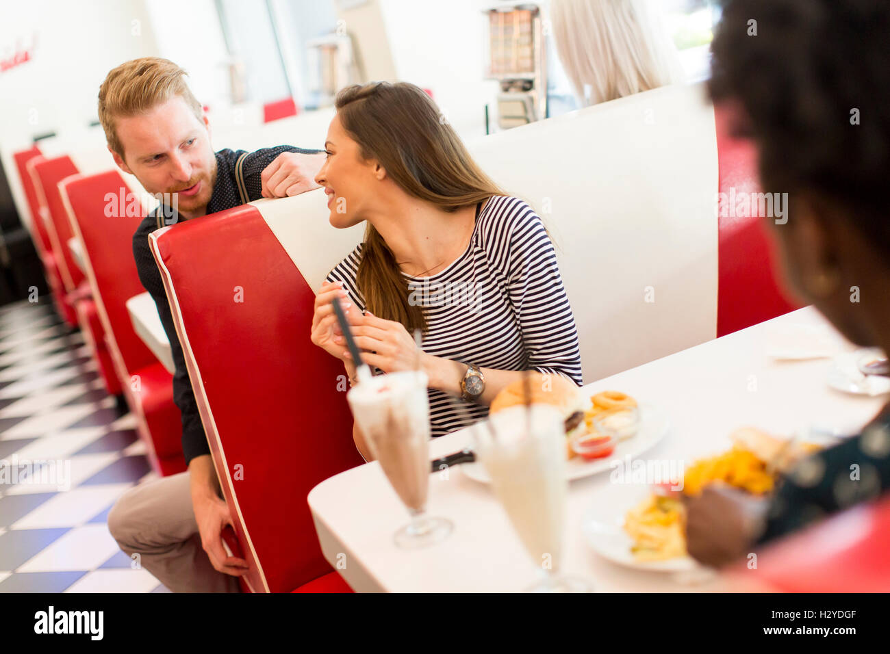 Friends eating fast food at the table in the diner Stock Photo - Alamy