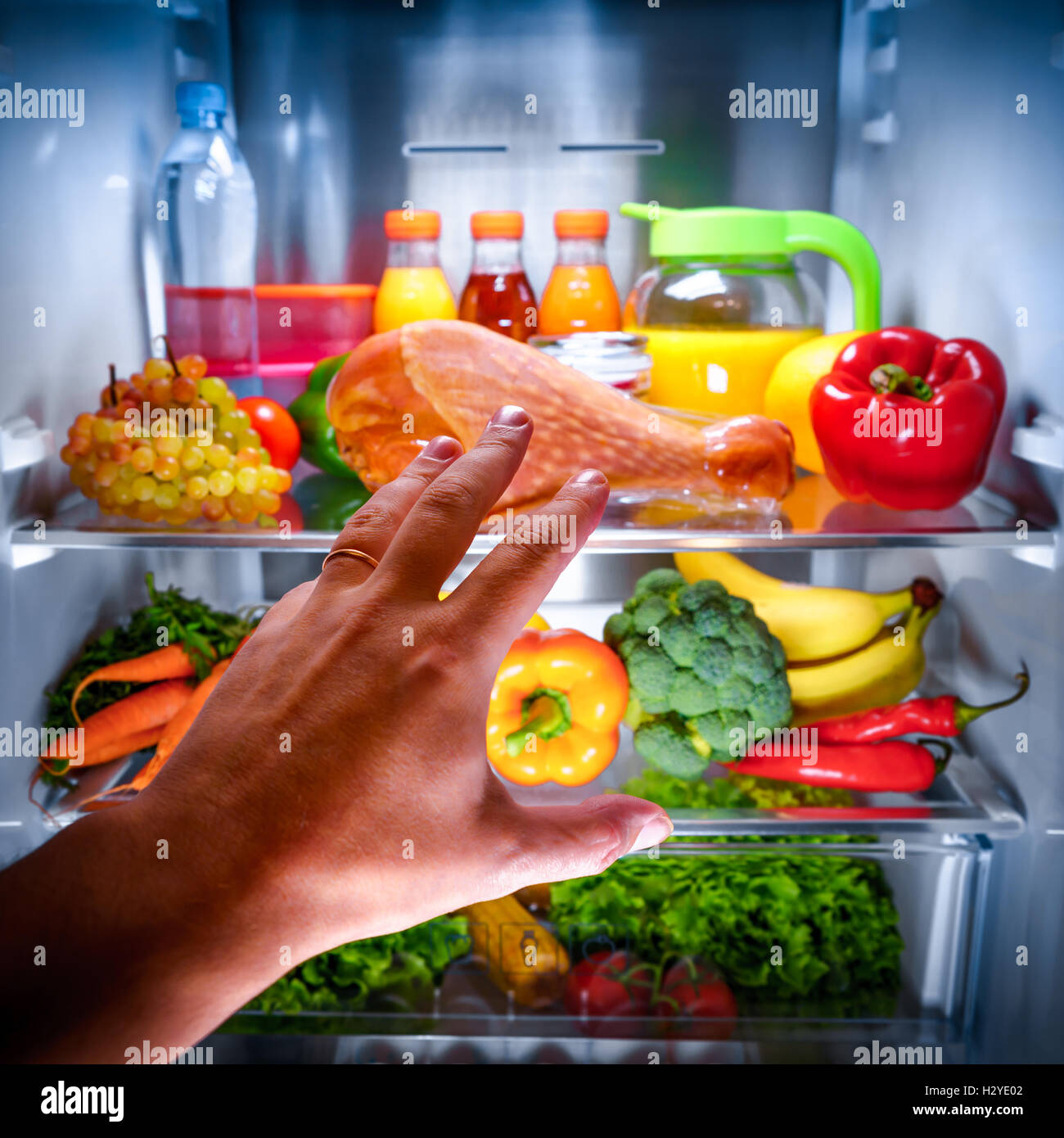Human hands reaching for turkey leg food at night in the open ...