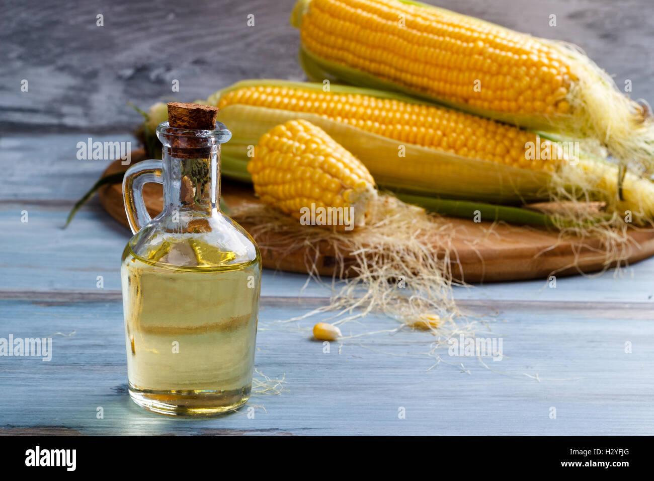 Fresh corn with bottle of oil on wooden background Stock Photo - Alamy