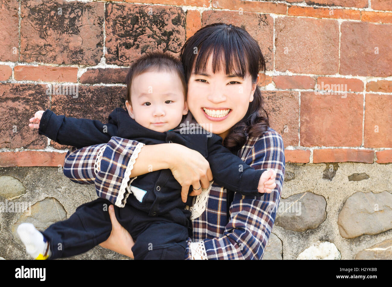 Mother and son stand in front of wall Stock Photo - Alamy