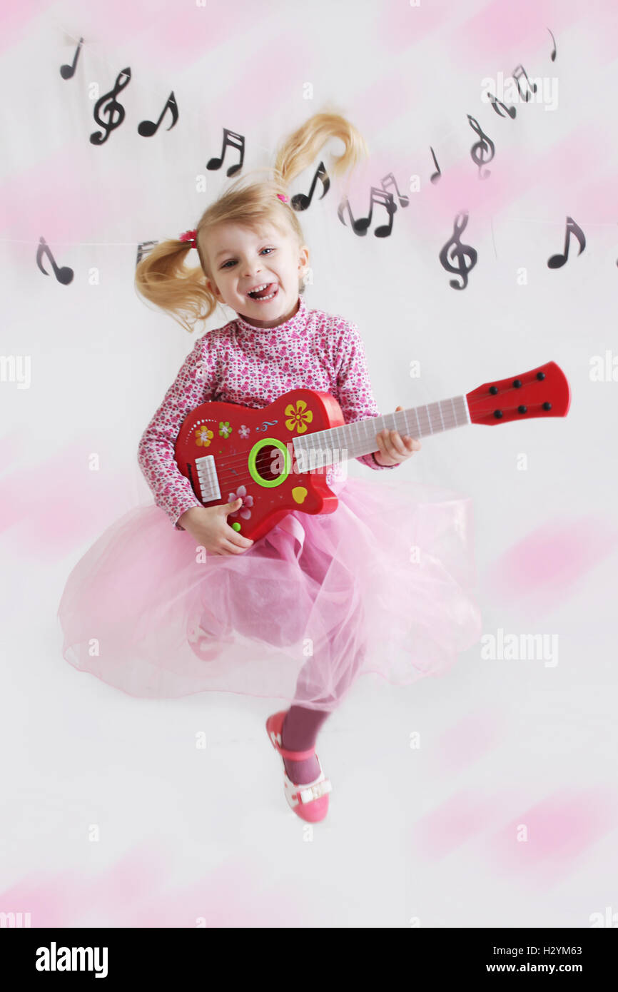 Girl with guitar on music notes background Stock Photo - Alamy