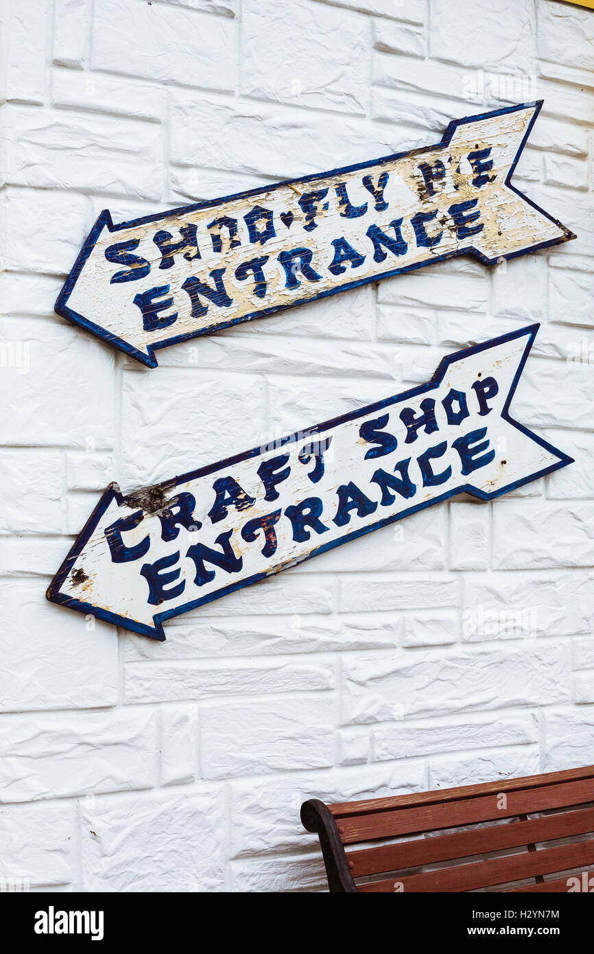 two entrance signs on white brick wall Stock Photo - Alamy