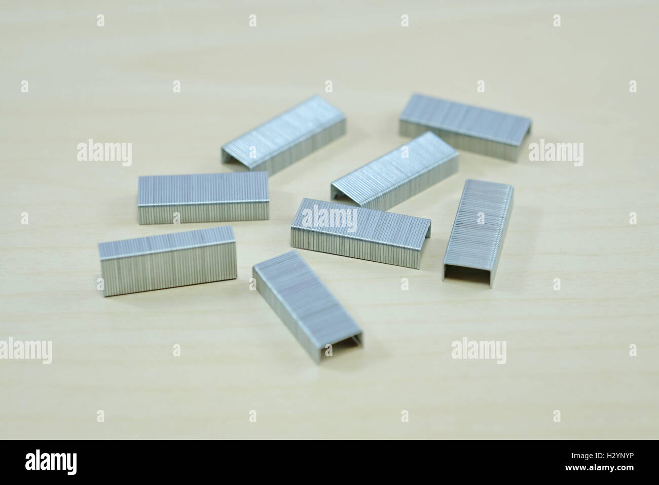 Staples on wood background Stock Photo - Alamy