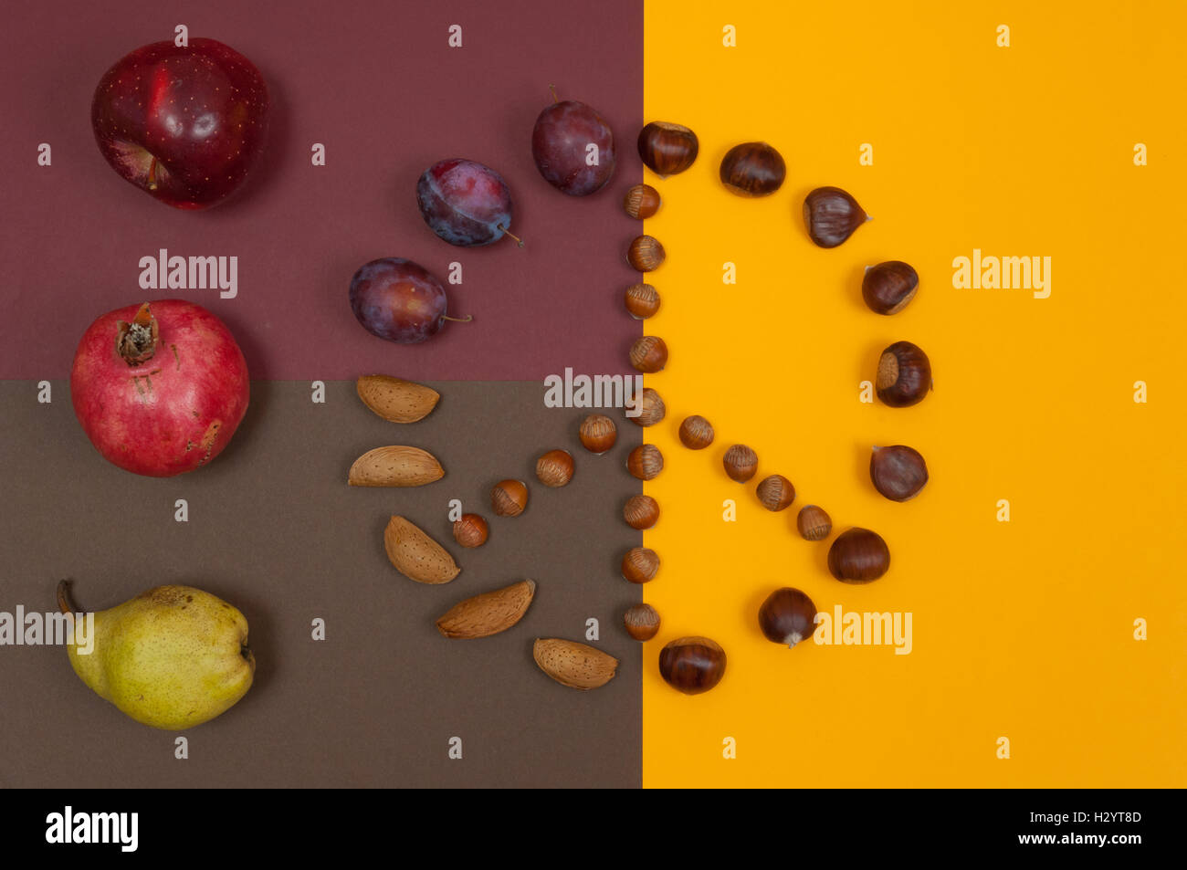 Peace symbol of in shell nuts and autumn fruits on split background ...
