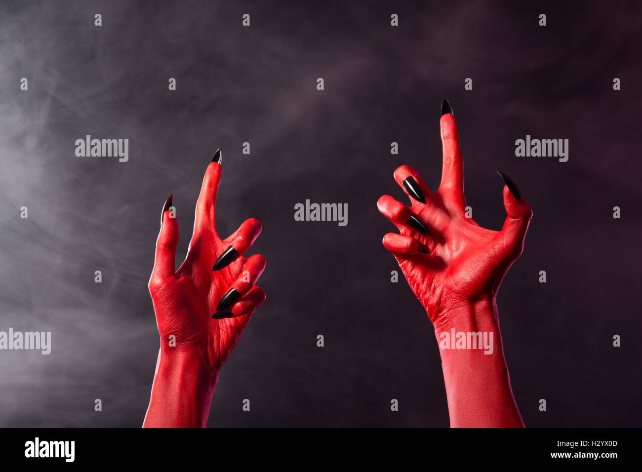 Creepy red devil hands with black sharp nails Stock Photo - Alamy