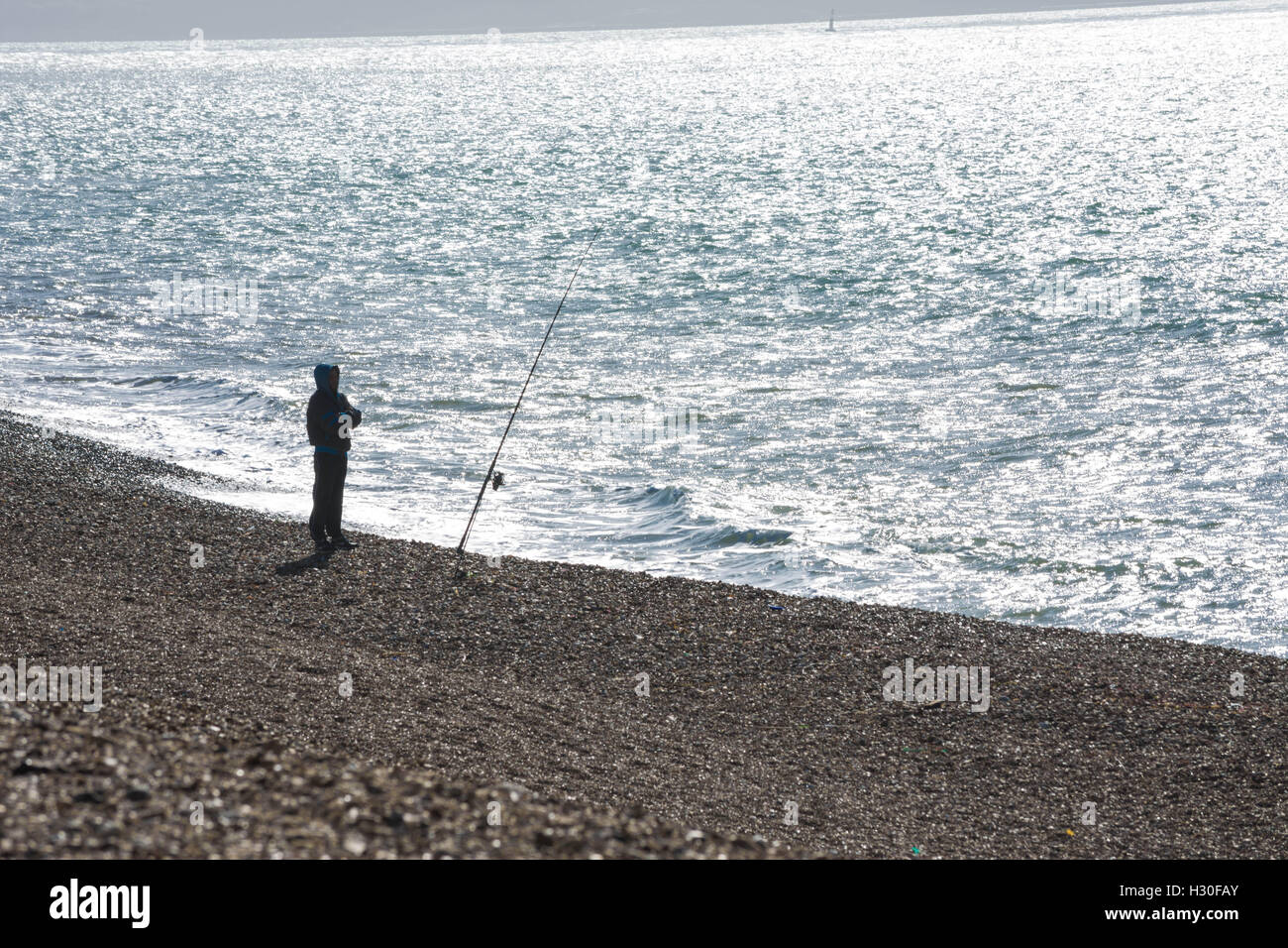 Sea angler fisherman attending to his rods Stock Photo - Alamy