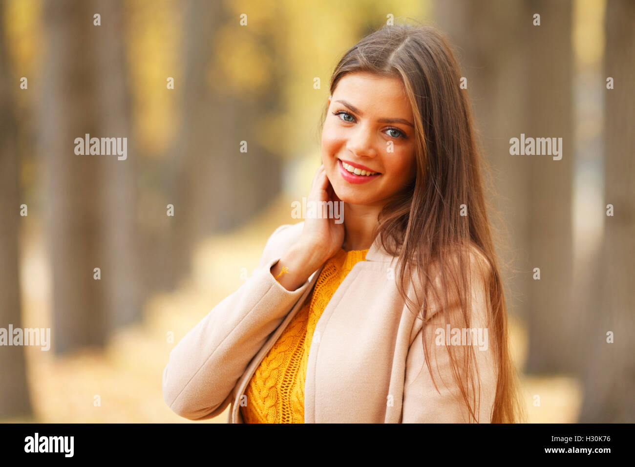 Beautiful woman walking at alley in autumn park Stock Photo - Alamy