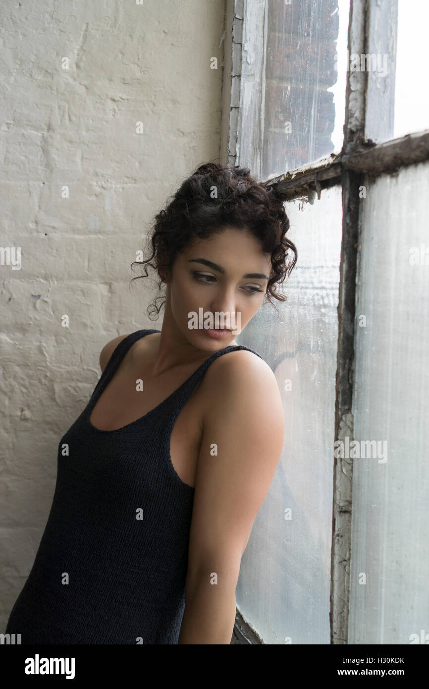 Sad young woman looking out of the window Stock Photo - Alamy