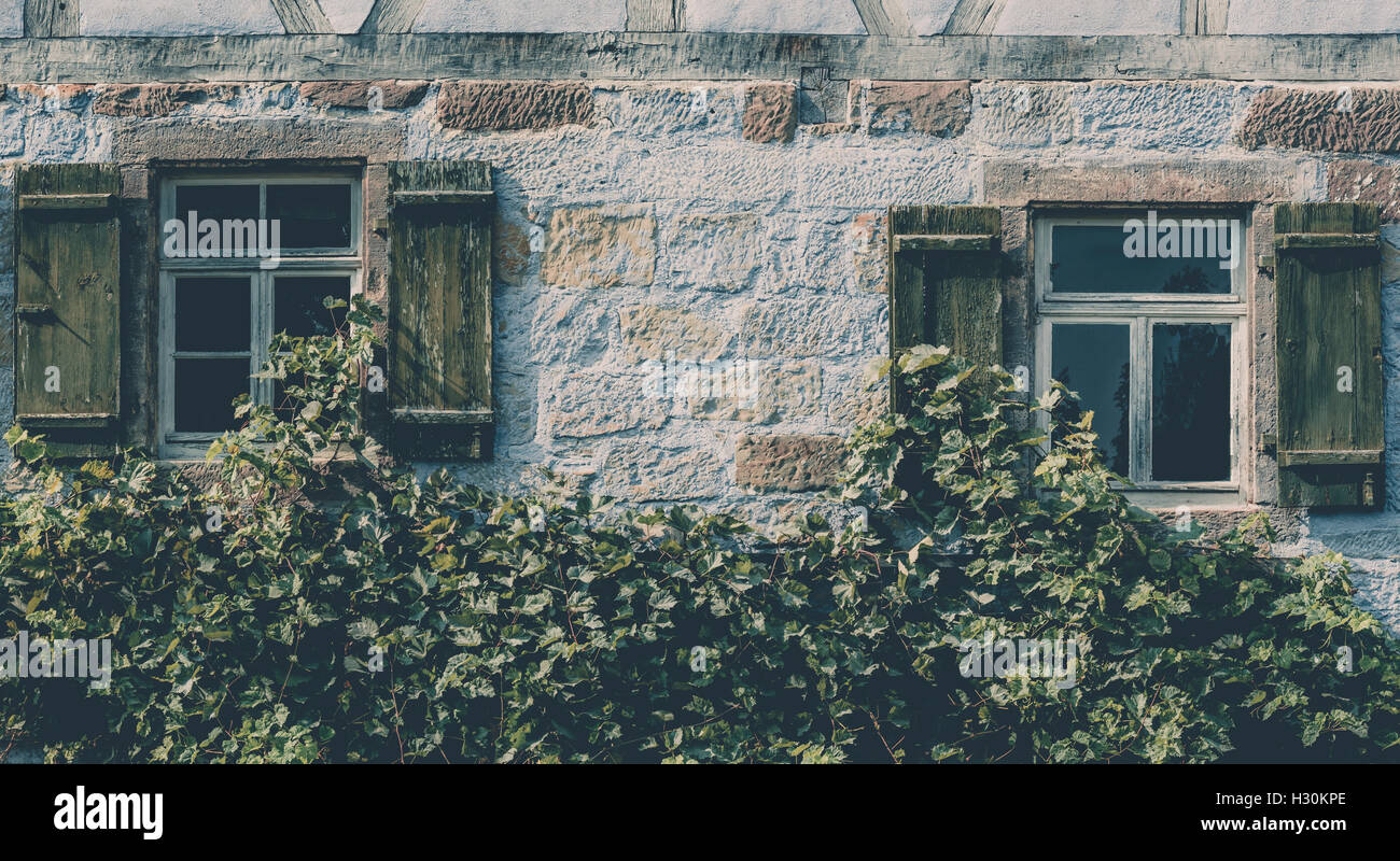 Traditional german house facade with two wooden windows and shutters, a ...