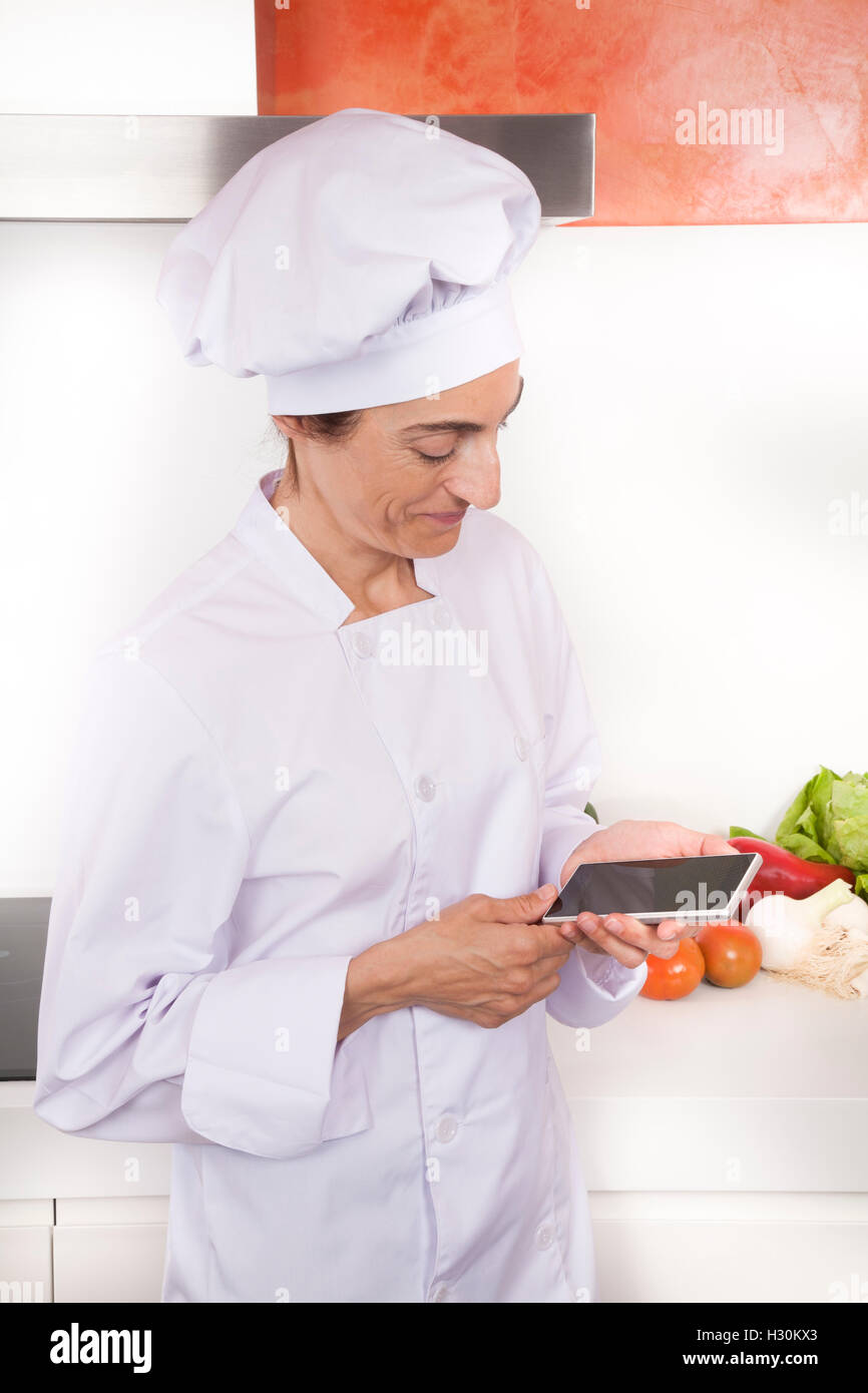 portrait of brunette happy chef woman with professional jacket and hat ...