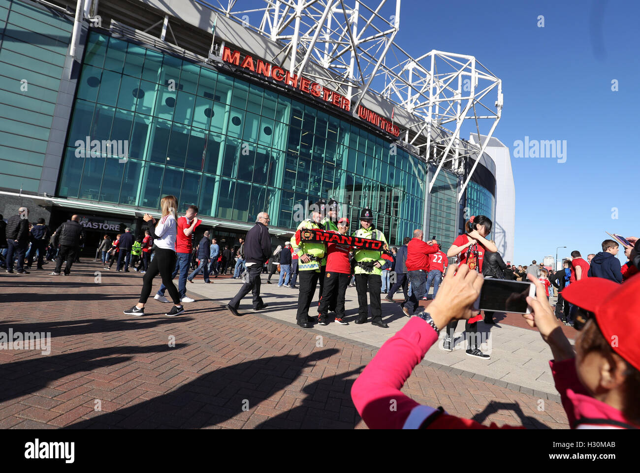 Fans pose for pictures with police officers before the Premier League ...