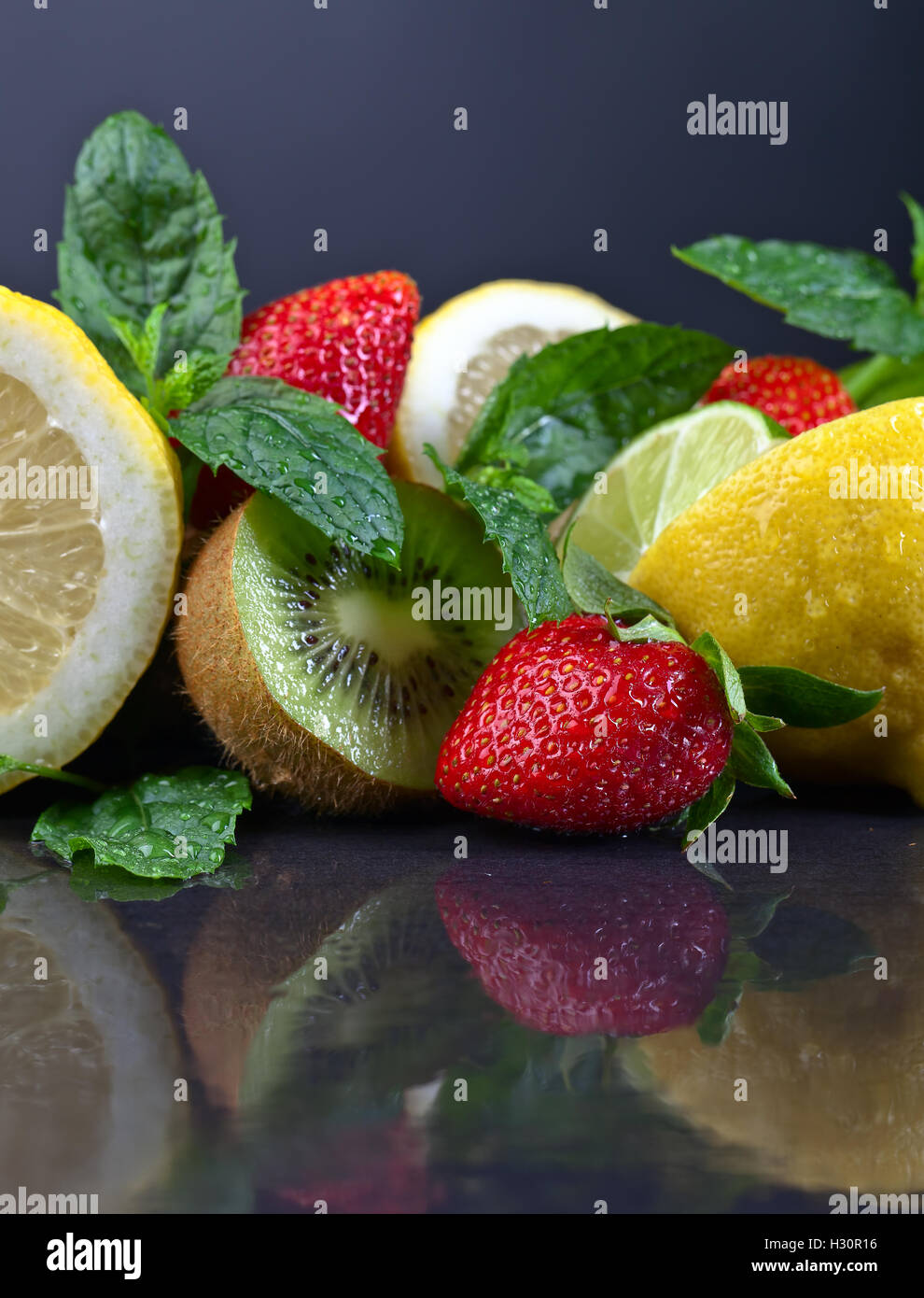 The ripe juicy fruits and peppermint leaves on a dark background Stock ...