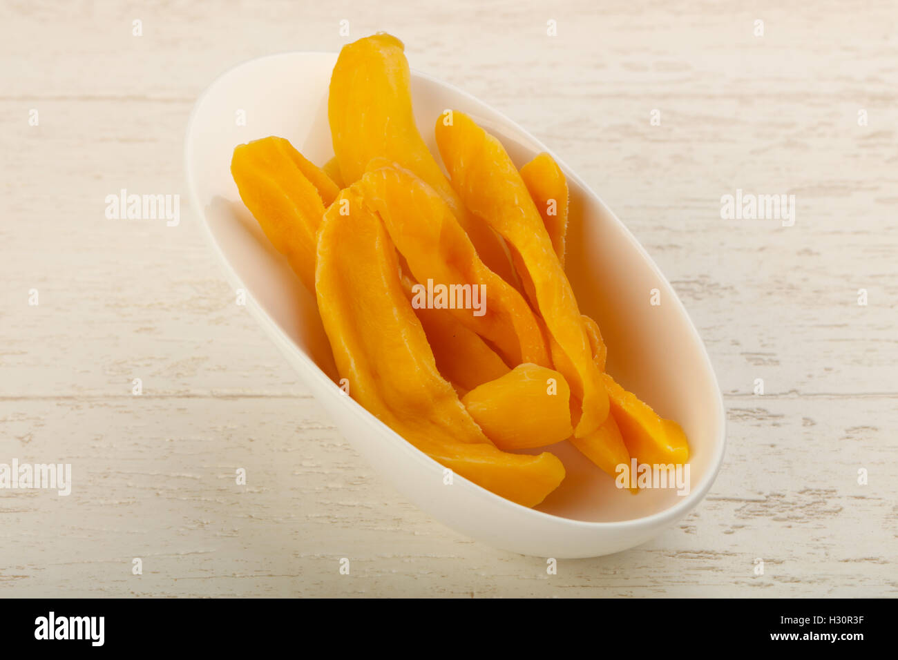 Dry mango chips heap in the bowl Stock Photo - Alamy