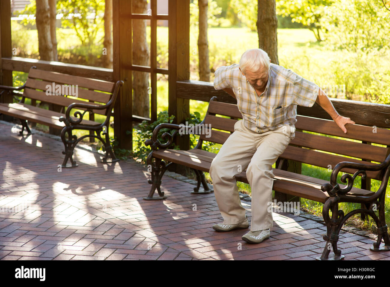 Senior man holding his back Stock Photo - Alamy