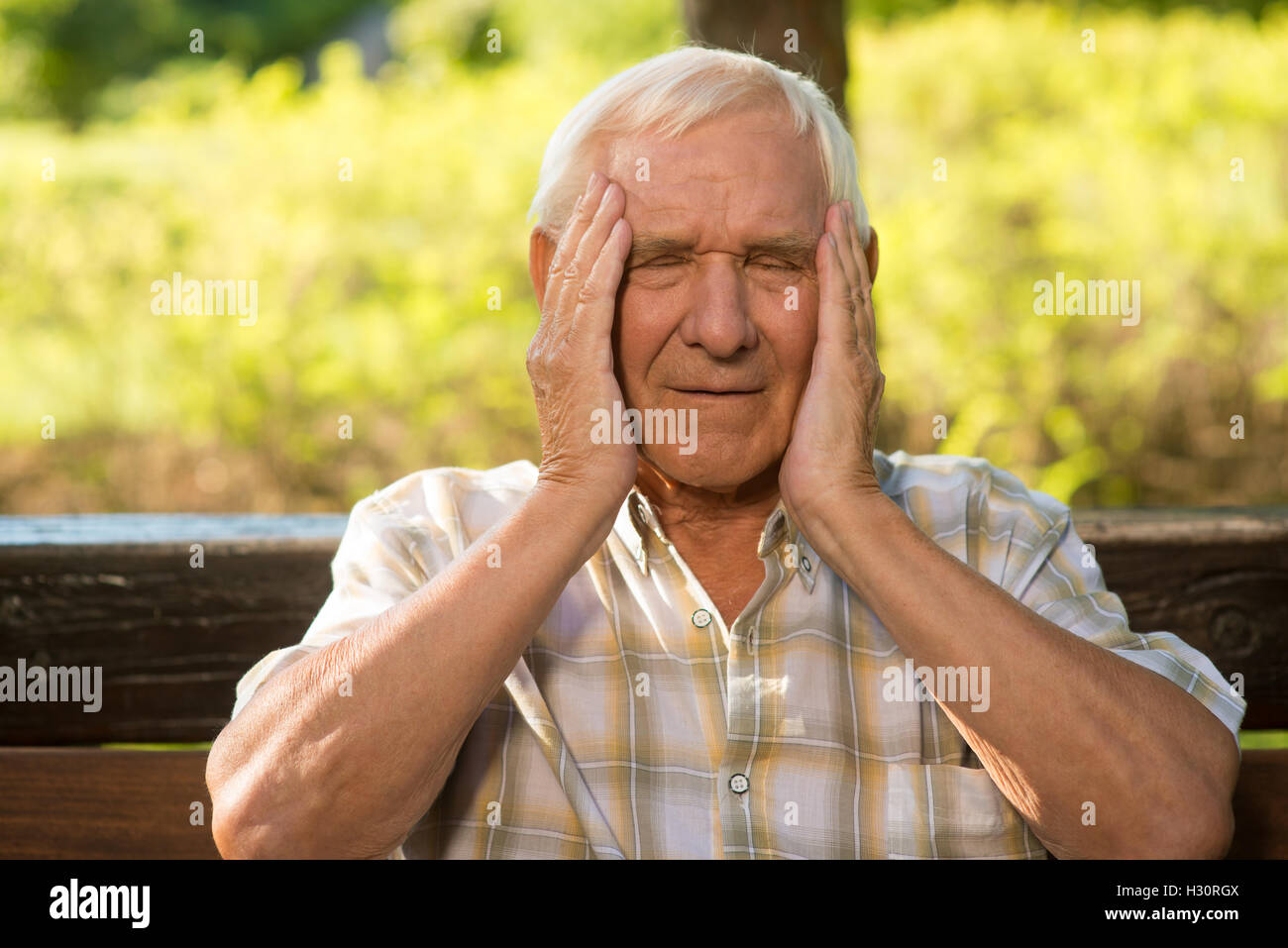 Elderly man has headache Stock Photo - Alamy
