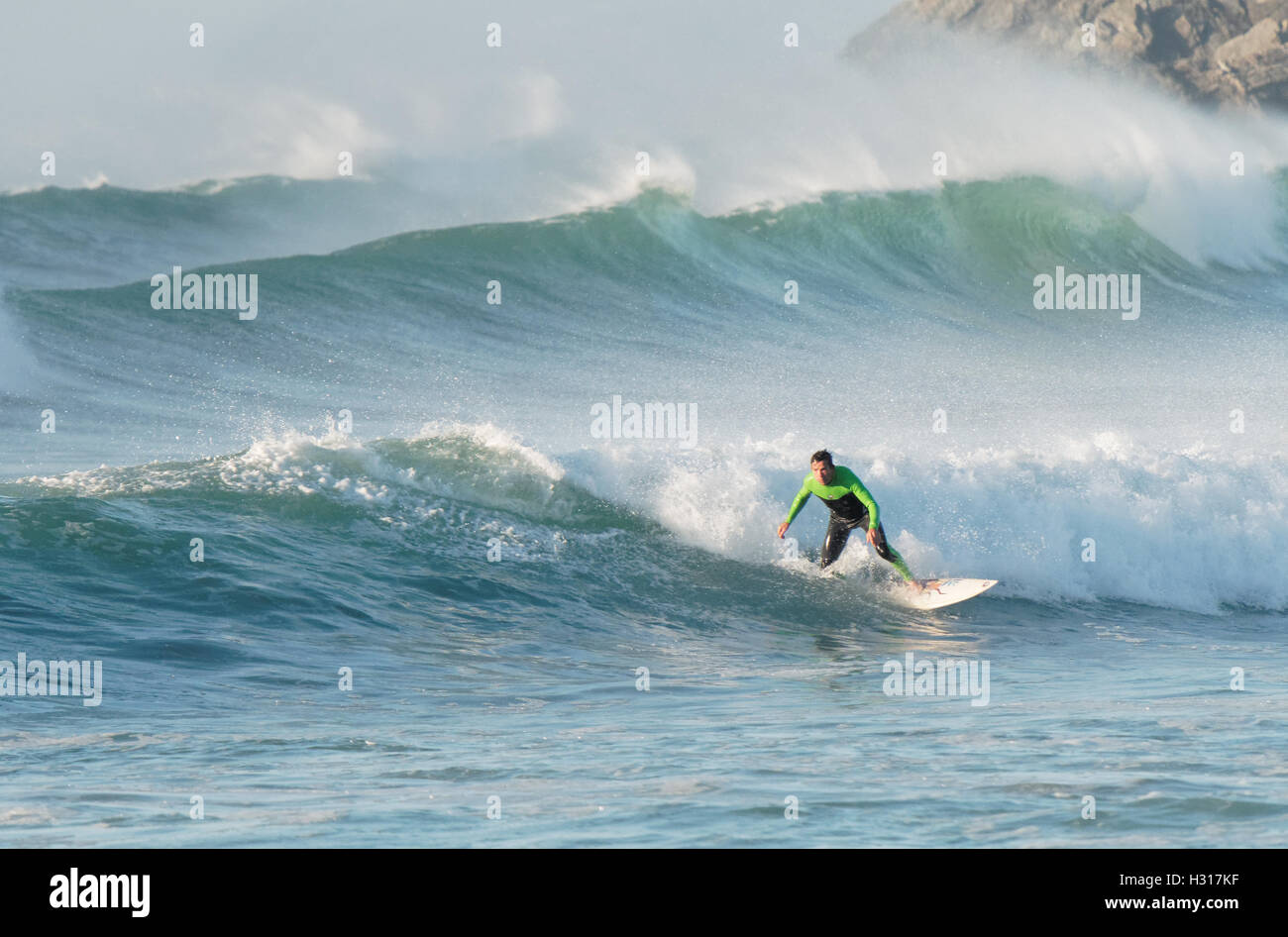 Lone surfer rides huge back lit sunshine surf UK Stock Photo - Alamy