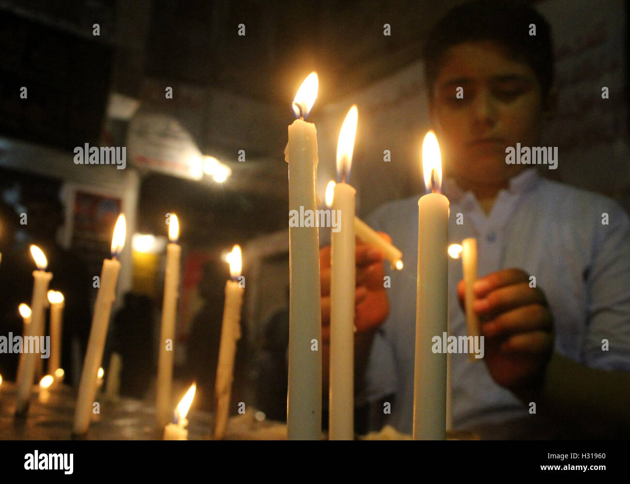 Peshawar. 3rd Oct, 2016. A Pakistani Shiite Muslim boy lights candles ...