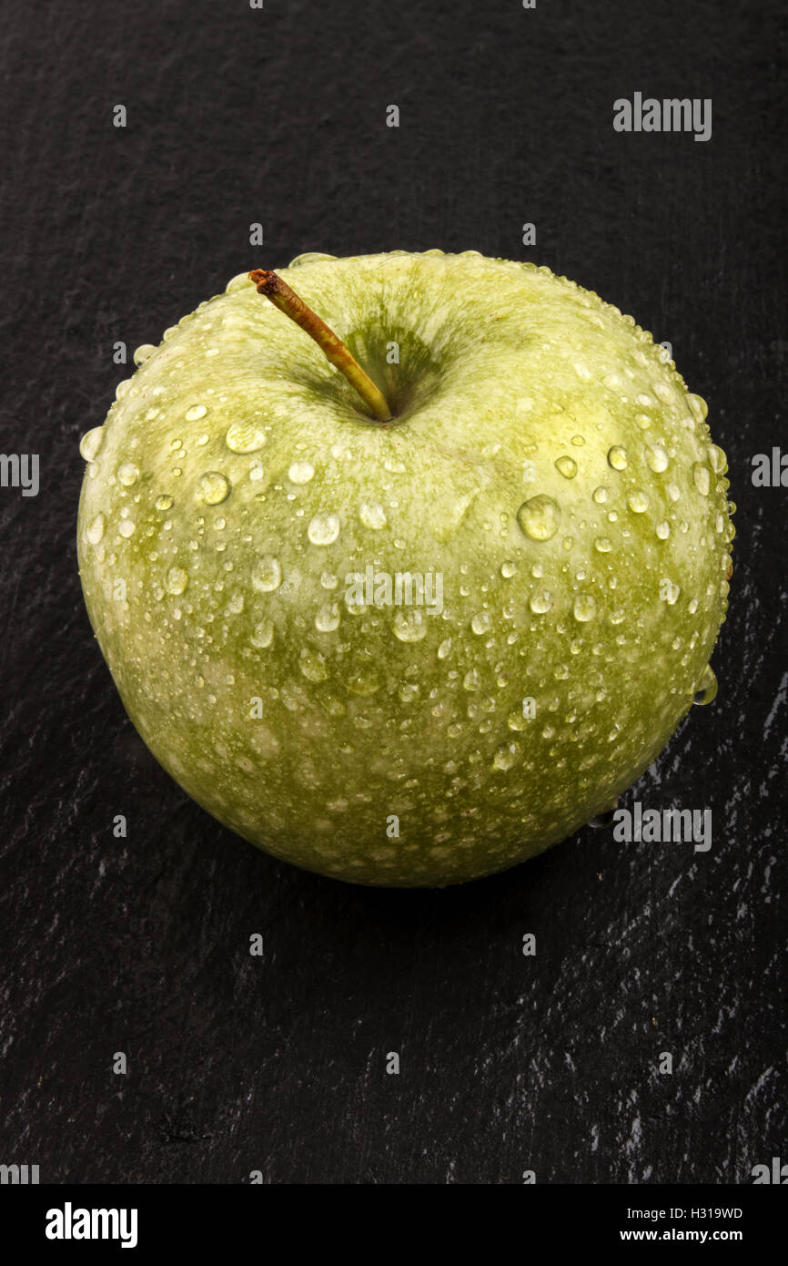one organic wet green apple on slate Stock Photo - Alamy