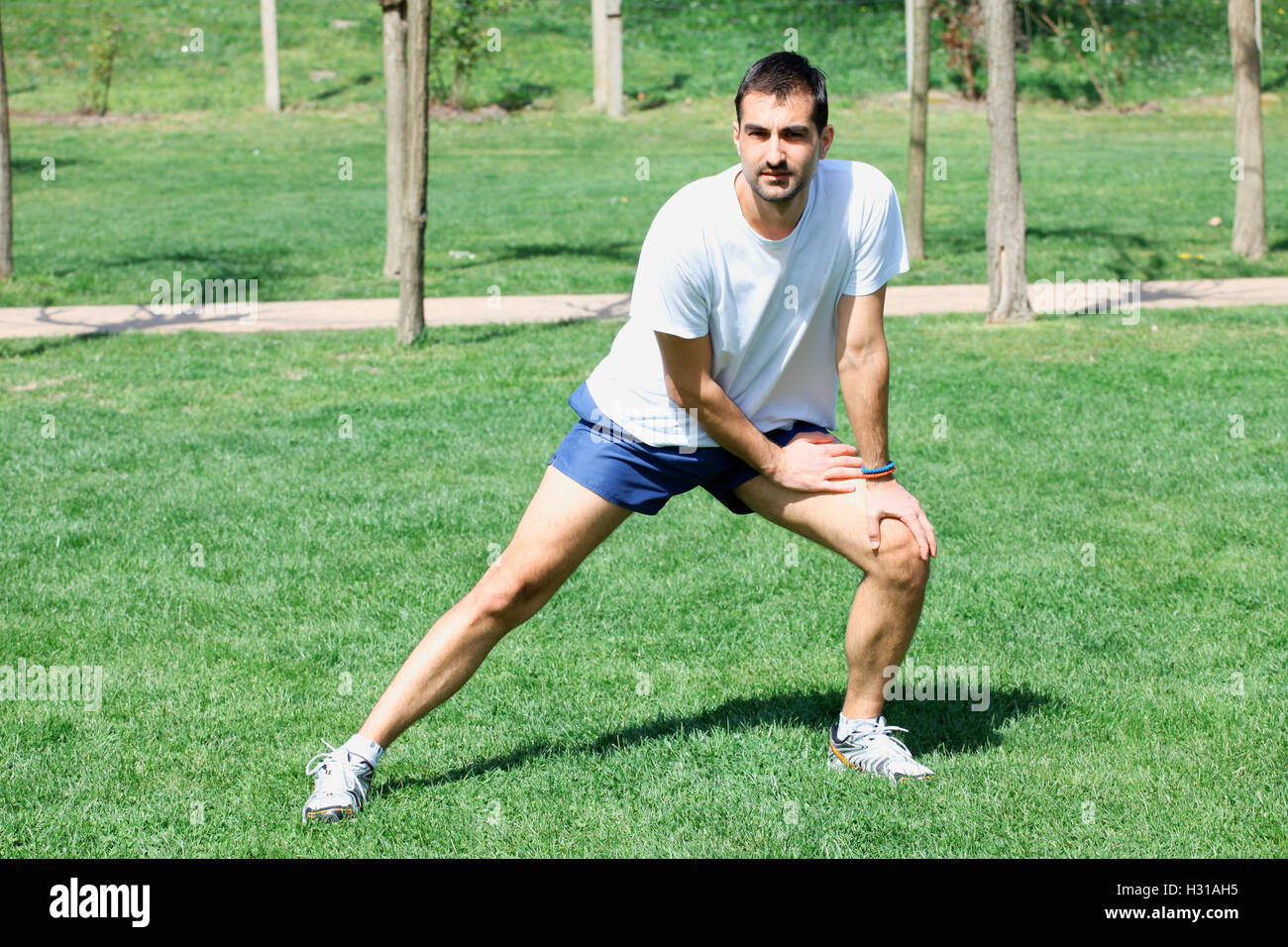Man stretching muscles at the city park Stock Photo - Alamy