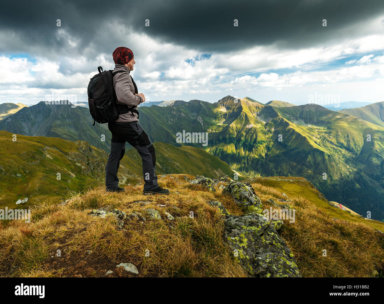 Man hiking with backpack into the mountains Stock Photo - Alamy